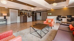 Um hall amplo com balcão de recepção, área de estar e kitchenette.