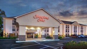 Um hotel Hampton Inn com um amplo estacionamento e entrada bem iluminada.