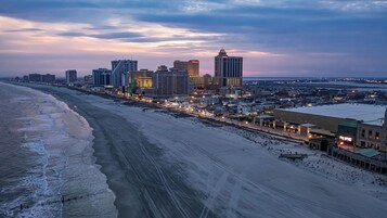 Paisagem costeira urbana com praia, edifícios altos e uma combinação de estruturas comerciais e residenciais.