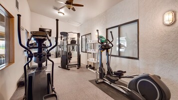 Uma academia em casa com diversos equipamentos de exercício, incluindo esteiras, bicicleta ergométrica e aparelhos de musculação.