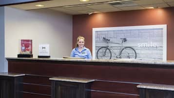 Uma receção com um cartaz de bicicleta emoldurado e um sinal para Hilton Honors.
