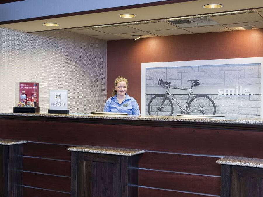 Uma receção com um cartaz de bicicleta emoldurado e um sinal para Hilton Honors.