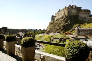 Um castelo histórico numa colina com vista para uma cidade.