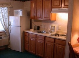 Um frigorífico, um micro-ondas, uma cafeteira/bule 