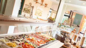 Buffet com diversos alimentos, incluindo frutas, vegetais e carnes.