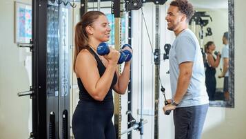 Uma academia com equipamentos de ginástica e um espelho.