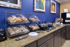 Uma mesa de buffet com diversos alimentos e utensílios de servir.