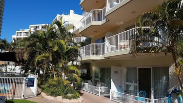 Um hotel com vários andares, varandas, área de recepção e piscina.