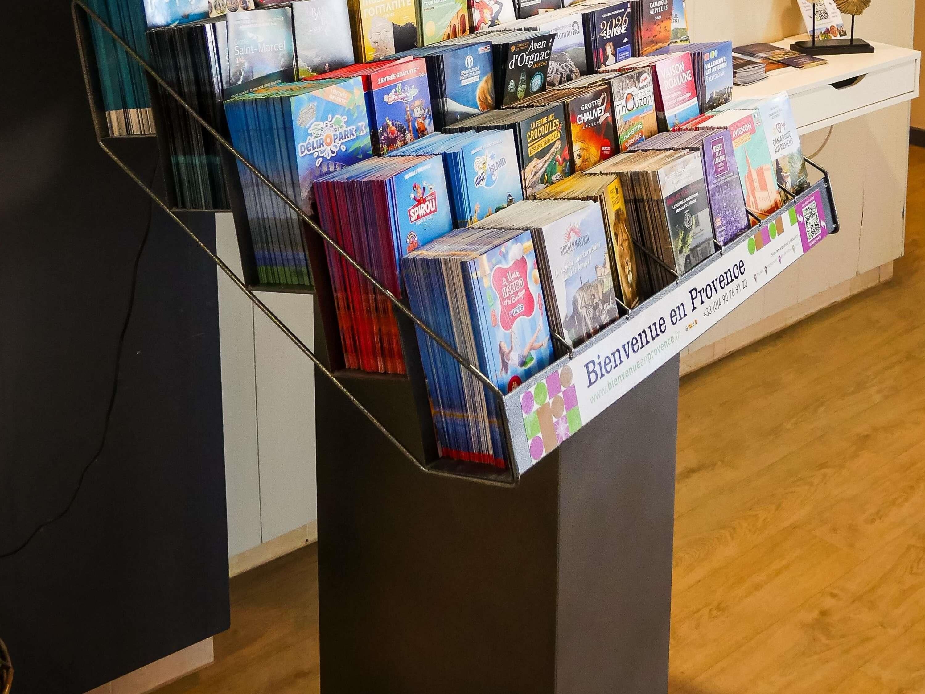 Exposição de livros com uma placa que diz 'Bienvenue en Provence' e um endereço de site.