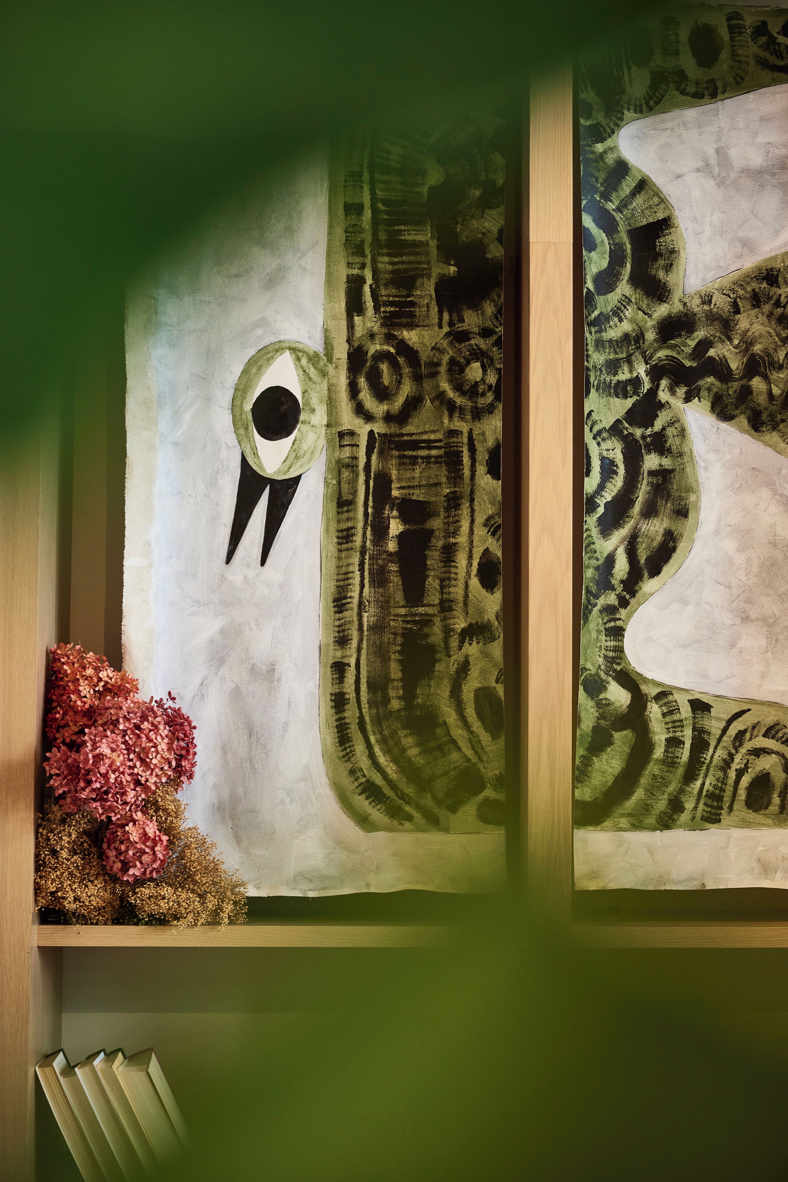 Paredes com uma grande pintura abstrata com um pássaro e uma serpente.
