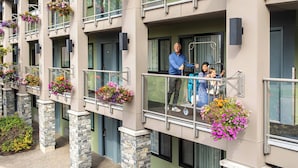 Um edifício com vários andares e varandas decoradas com cestos de flores.