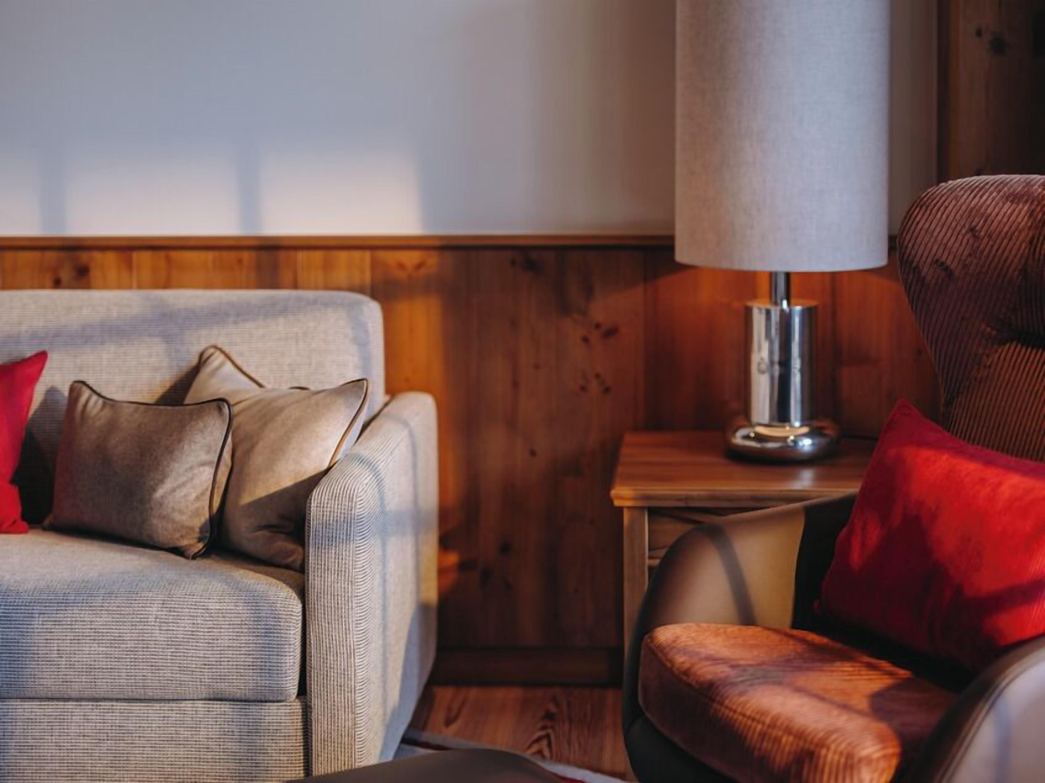 Uma sala de estar aconchegante com um sofá, uma mesinha de madeira e uma luminária.