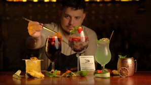 Um bar com diversas bebidas, um cardápio e utensílios de bar.