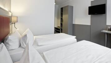 Quarto de hotel com duas camas, uma televisão presa na parede e um guarda-roupa.