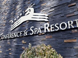 Placa para um resort de conferências e spa, com um logotipo estilizado de um veado e estrelas.