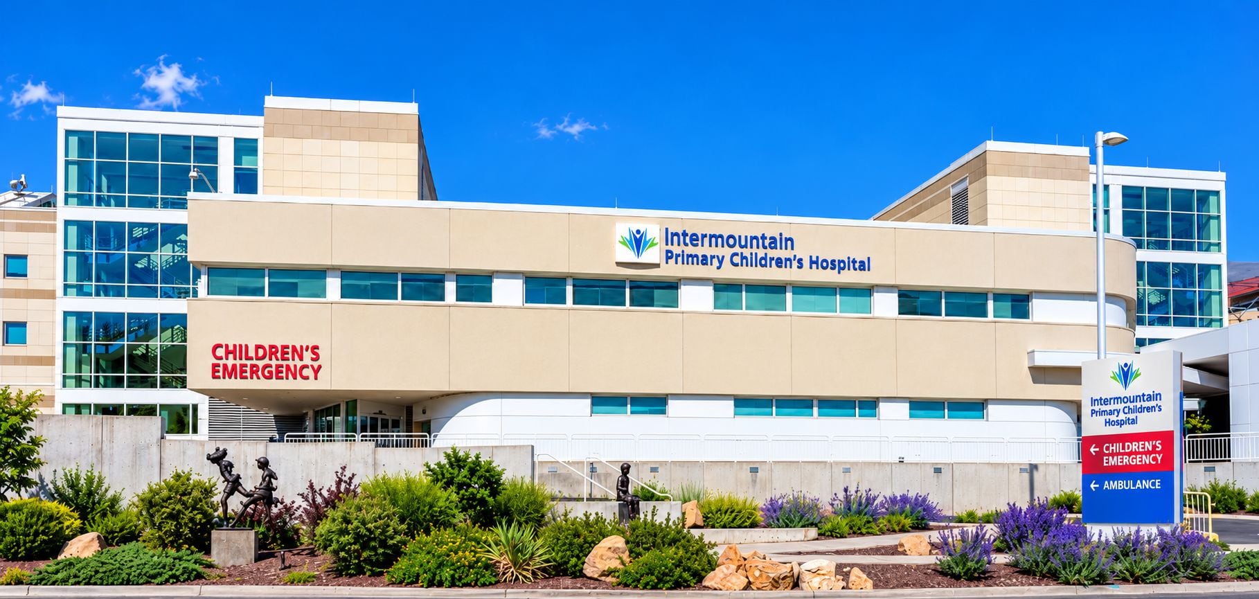 Um edifício moderno com placas indicando o Hospital Infantil Intermountain e Emergência Pediátrica.