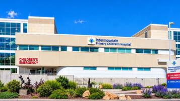 Um edifício moderno com placas indicando o Hospital Infantil Intermountain e Emergência Pediátrica.