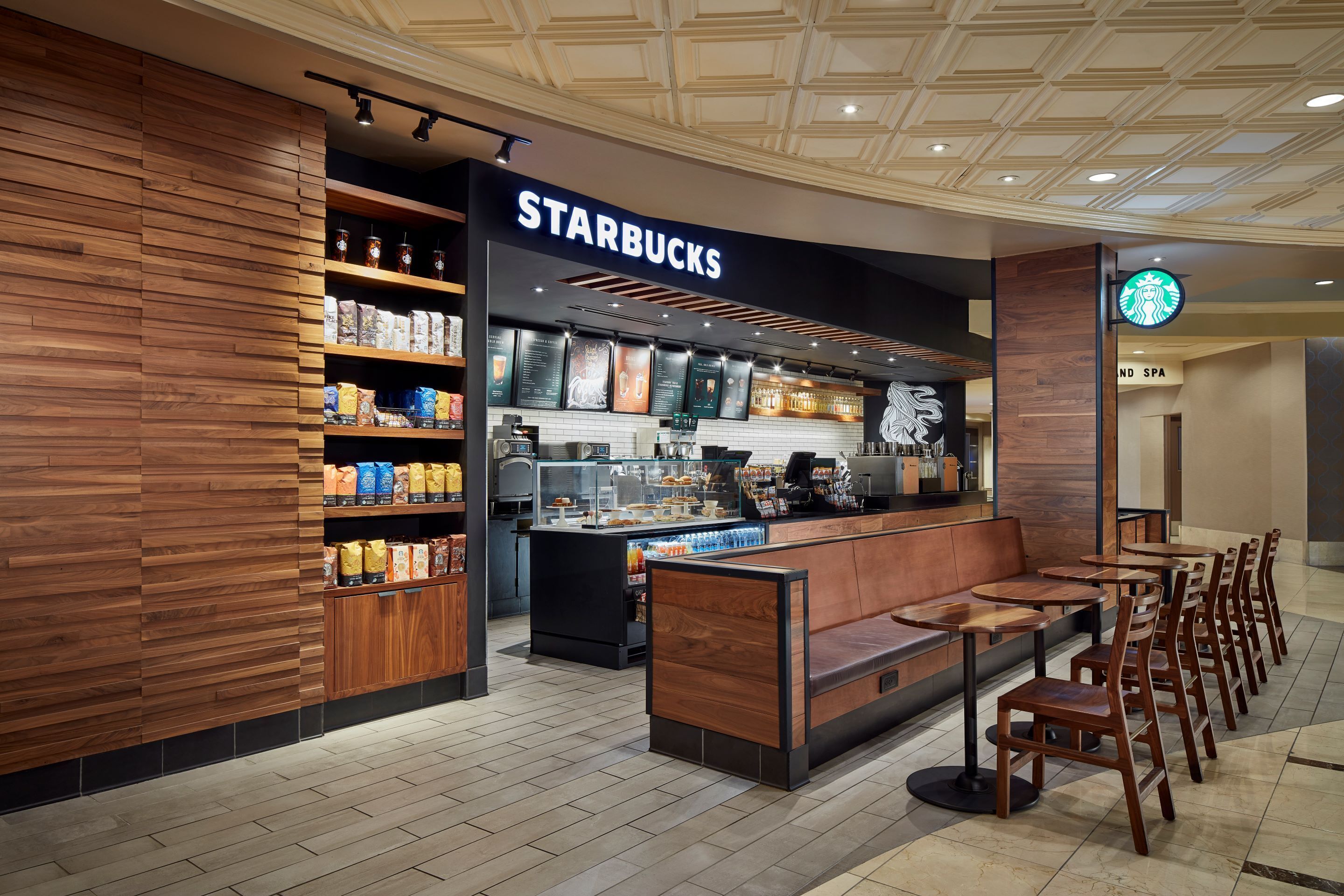 Um Starbucks com decoração em madeira, área de estar e exposição de produtos de café.
