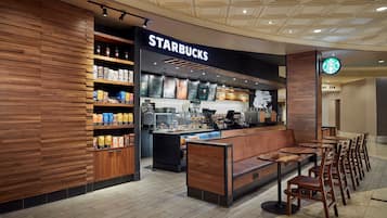 Um Starbucks com decoração em madeira, área de estar e exposição de produtos de café.