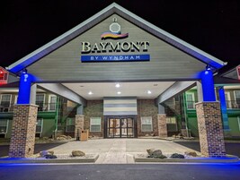 Entrada de um hotel com uma placa indicando "Baymont by Wyndham".