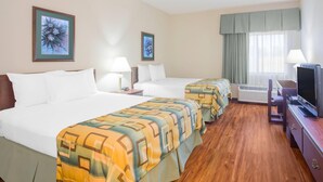 Quarto de hotel com duas camas, televisão e janela com cortinas.