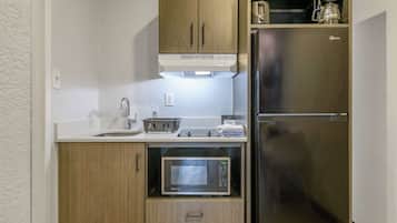 Um frigorífico/congelador grande, um micro-ondas, uma placa de cozinha