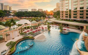 Um resort com uma grande piscina, espreguiçadeiras e um gazebo.