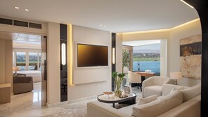 Uma sala de estar moderna com sofá, mesa de centro e TV na parede.