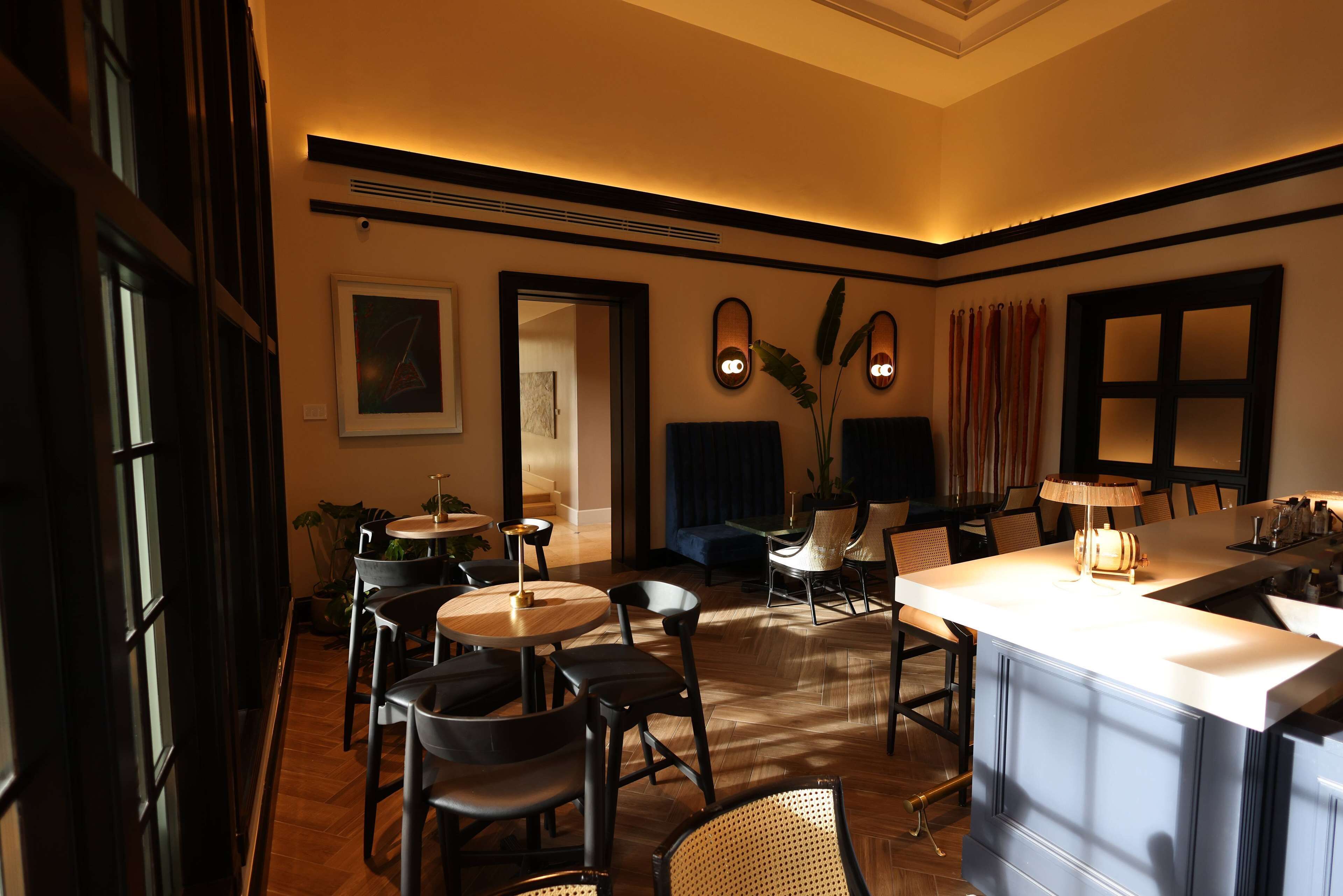 Um saguão de hotel com área de bar, assentos e uma grande janela.