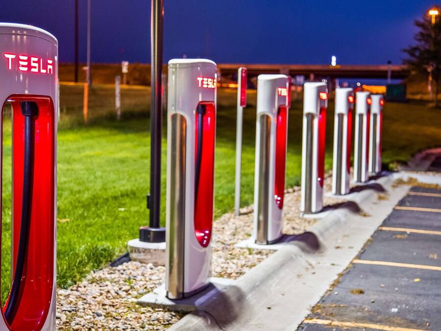 Várias estações de carregamento Tesla em um estacionamento.