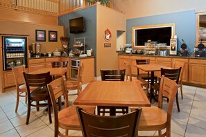 Restaurante com mobiliário de madeira, máquina de café e televisão fixada na parede.
