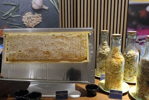 Exposição de favos de mel, flocos de milho e diversos grãos.