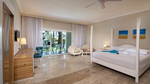 Quarto de hotel com uma cama, escrivaninha, cadeira e vista para o exterior.