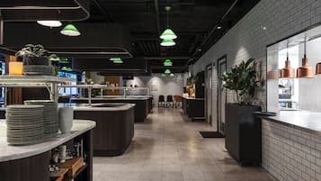 Interior de restaurante moderno, com balcão extenso, várias áreas de estar e iluminação pendente.