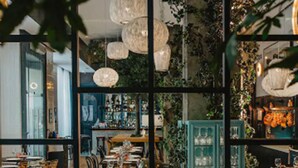 Um interior acolhedor com área de refeições, bar e espaço de estar com cadeiras e mesas laranja.