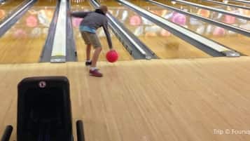 Uma pista de boliche com várias pistas e uma pessoa jogando.