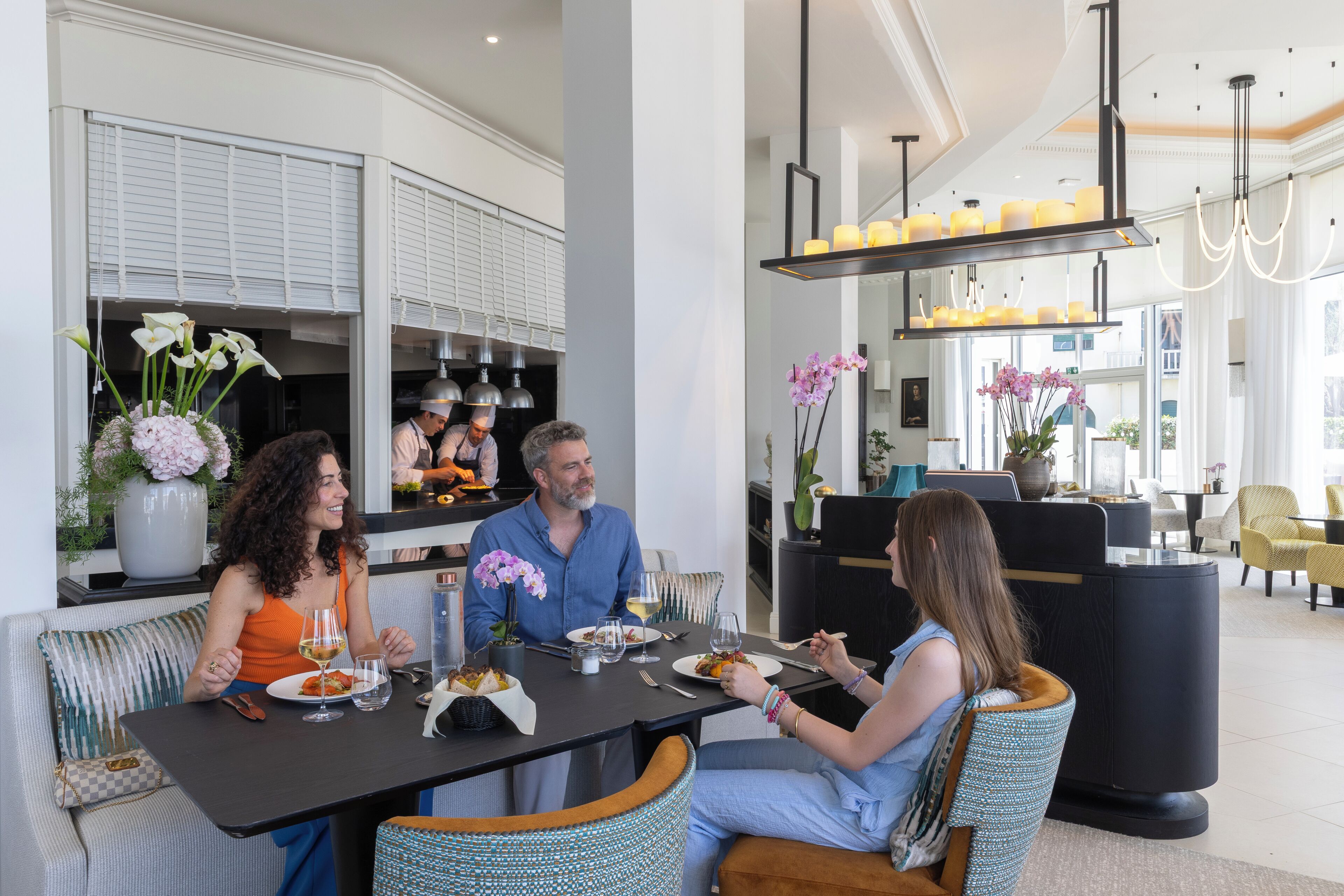 Uma sala de jantar com uma mesa, cadeiras e vista para a cozinha.