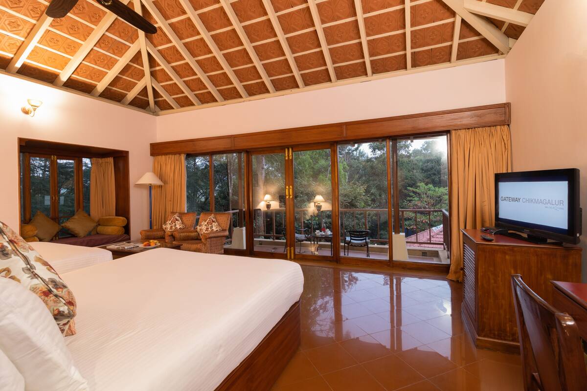 Quarto espaçoso com uma cama grande, televisão e varanda com vista para o exterior.