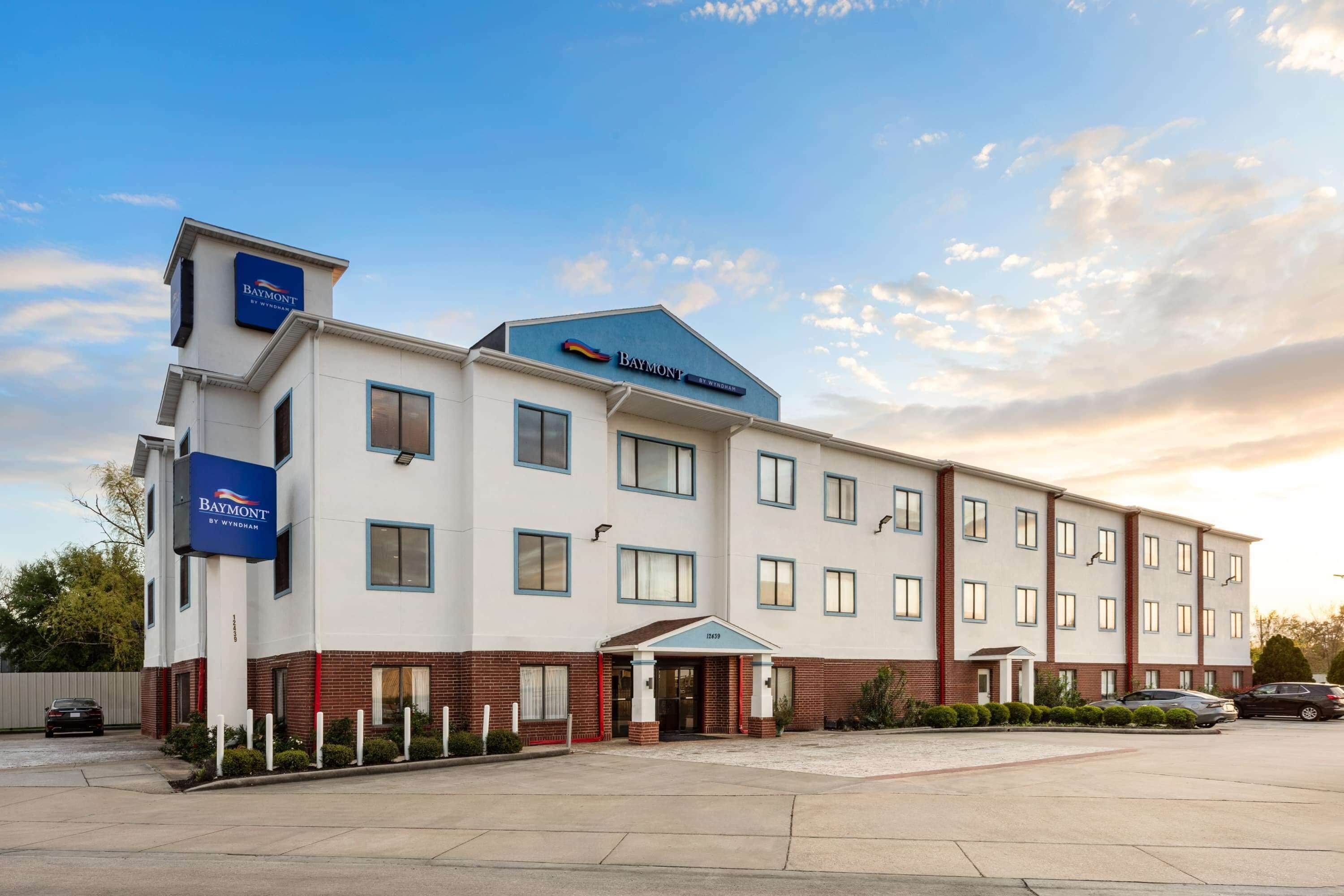Um hotel Baymont by Wyndham com estrutura de dois andares, fachada de tijolos e estacionamento.