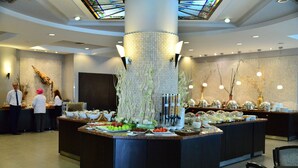 Disposição de buffet com diversos alimentos e um arranjo decorativo.