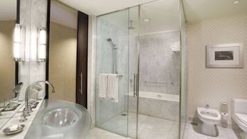 Uma casa de banho moderna com cabine de duche em vidro, lavatório generoso em vidro e espaço sanitário separado.