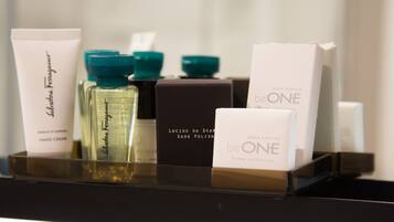 Exposição de diversos produtos de cuidados para a pele e perfumes numa prateleira preta.