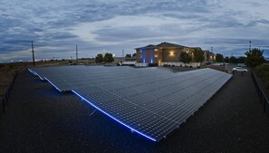 Um grande painel solar com um edifício ao fundo.