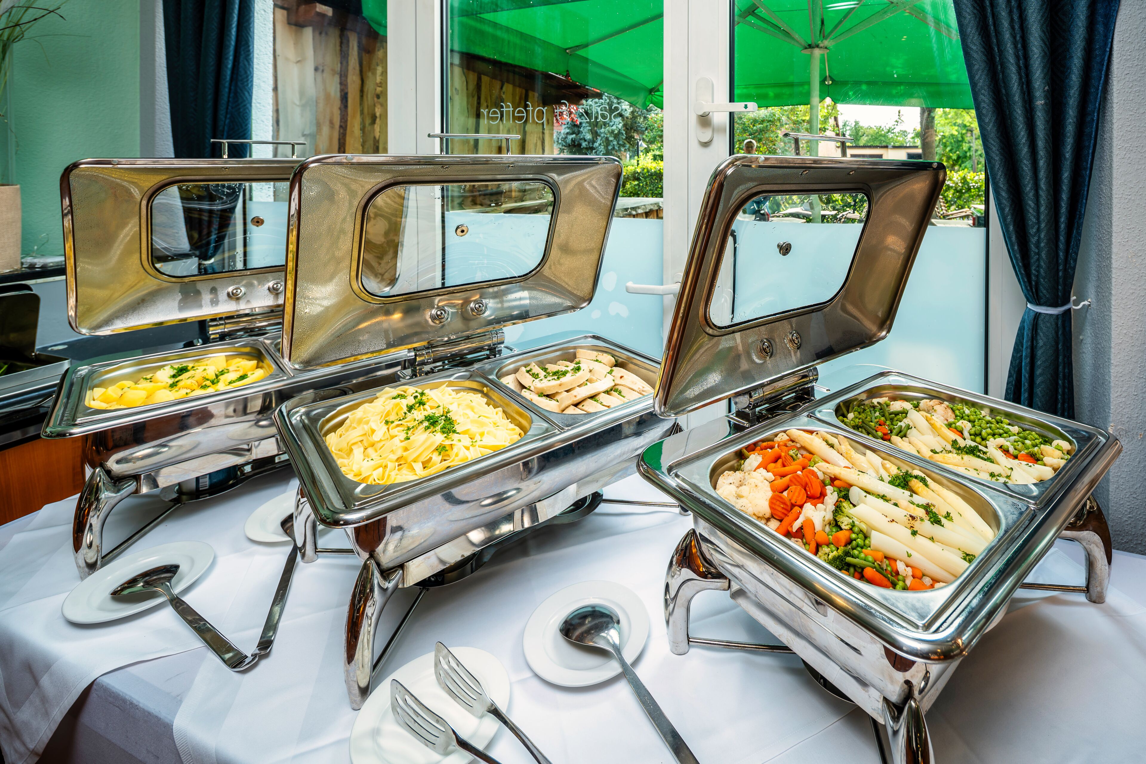 Uma mesa de buffet com várias estações de serviço de comida.