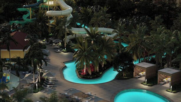 Área de piscina do resort com escorregador, cadeiras de descanso e palmeiras.