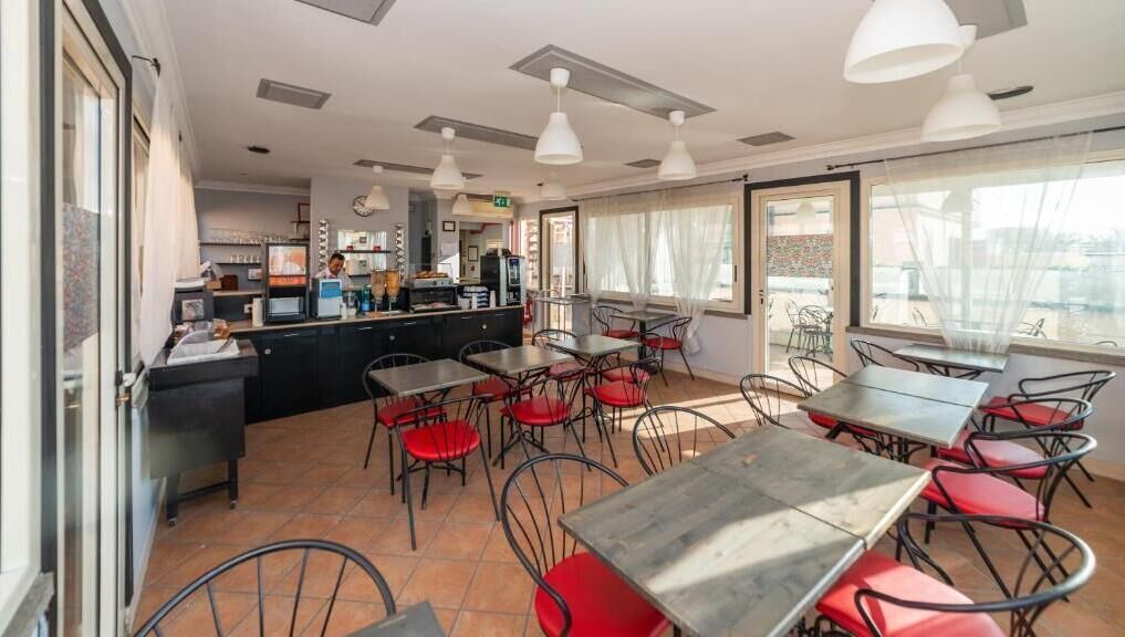 Um restaurante com área externa, um bar e grandes janelas.