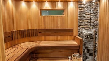 Uma sauna com bancos de madeira, parede de pedra e uma janela.