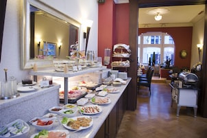 Buffet com diversos alimentos e um espaço para café.