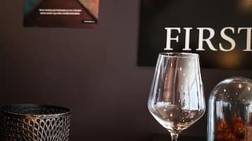 Uma mesa com uma taça de vinho, um letreiro de menu e um livro intitulado 'UNNGA OMVEIER' na parede.