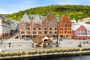 Um edifício histórico com estilo arquitetônico europeu tradicional, com vários andares e um telhado em mansarda imponente.